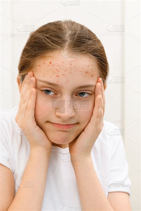 一个十几岁女孩的脸她看着镜子里的自己用她的手触摸她的脸好的和干净的皮肤是一个美丽和健康的概念