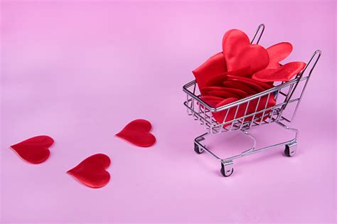 장바구니 안에 빨간 하트 빨간 하트로 가득 찬 미니 트롤리 발렌타인 데이 휴일 결혼식 또는 생일을 분홍색 배경에 인사말 카드 0