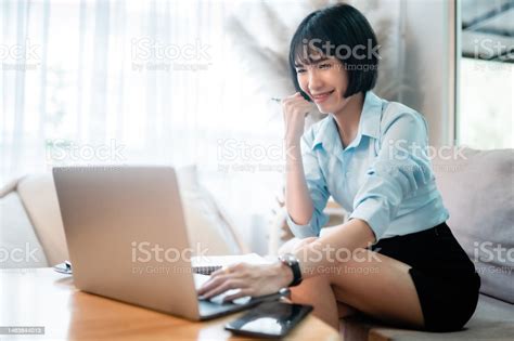 아시아 프리랜서의 치과 교정기로 행복한 미소를 짓고 있는 비즈니스 여성 캐주얼은 커피숍의 카페 인테리어에서 커피 컵과 스마트폰이