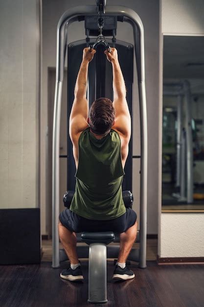 Premium Photo Back View Of Male Doing Exercise At Lat Pull Machine With Rope Handle