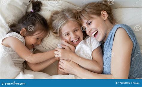 Allegra Famiglia Di Madre Sorridente Con Due Figlie Che Stanno Insieme