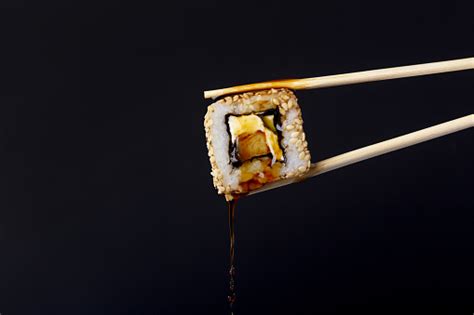검은 배경에 젓가락 사이 즙이 롤 초밥 음식 배경 일본 요리에서 떨어지는 간 장의 상품 젓가락에 대한 스톡 사진 및 기타 이미지 젓가락 쥠 초밥 Istock