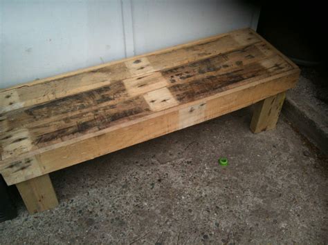 A Wooden Bench Sitting On Top Of A Cement Floor Next To A White Wall And Door