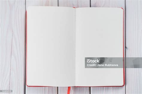 빨간 일기 나무 테이블 배경에 흰 종이 페이지가 있는 교과서 사무실 책상의 빈 통합 문서에 메모 작성 0명에 대한 스톡 사진 및