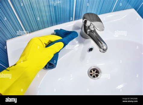 Clean Shiny Sink Close Up Gloved Cleaners Hand Wipes Sink With Rag