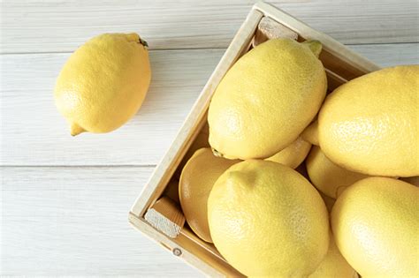 나무 상자에 잘 익은 레몬 흰색 나무 배경에 신선한 레몬 잘 익고 맛있는 감귤류 과일 텍스트공간을 복사합니다 맨 위 보기입니다