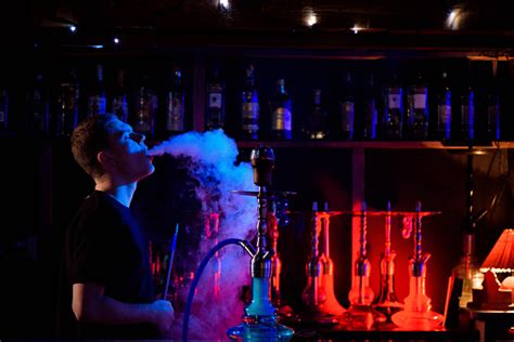 남자는 전통적인 Hookah 파이프를 흡연하고 Hookah 카페에서 연기를 내뿜는다 건강한 식생활에 대한 스톡 사진 및 기타