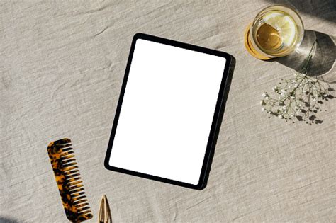 빈 화면 태블릿 모형 레몬 석고 꽃 린넨 식탁보와 테이블에 머리 빗물 물 한 잔 플랫 레이 상단 보기 북유럽 스칸디나비아 스타일 여성스러운 홈 오피스 데스크 패션에 대한