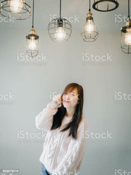 천장에 텅스텐 램프와 직장 및 건축 장식 항목 또는 격리 된 화이트 룸 배경 벽에서 스웨터를 뜨개질에 여 자가 사랑에 행복에서