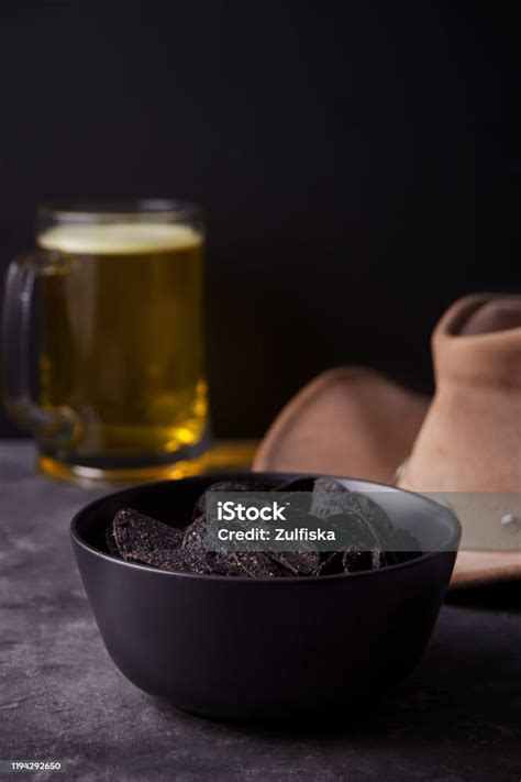 멕시코 옥수수 칩 나초 맥주와 카우보이 모자 한 잔 잔인한 남자를위한 검은 칩 나초 옥수수 속대에 대한 스톡 사진 및 기타