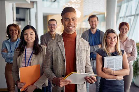 젊은 비즈니스 팀이 회사 건물 복도에 서서 사진을 찍기 위해 포즈를 취하고 있습니다 비즈니스 사람 회사 건강한 생활방식에 대한 스톡 사진 및 기타 이미지 Istock