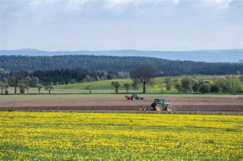 Premium Photo Tractor Planting Potatoes In The Springtime Farm