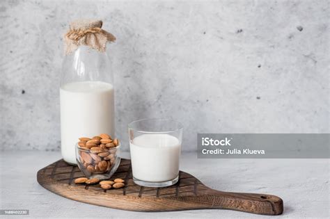 유리 병에 담긴 유기농 아몬드 우유는 돌 테이블 위의 세련된 나무 판자 위에 아몬드 옆에 있습니다 천연 친환경 제품 0명에 대한 스톡 사진 및 기타 이미지 Istock