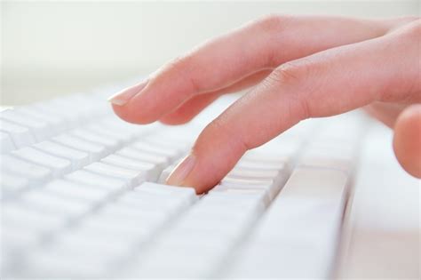 Close Up Of Hands Typing On Keyboard In The Workplace Free Photo
