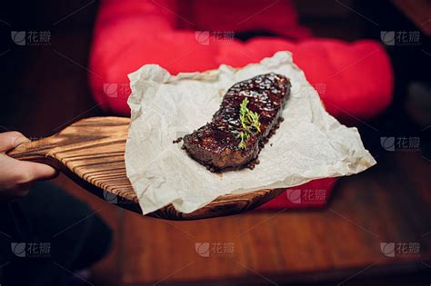 手从桌上拿起盛着烤肉的木托盘餐厅菜单服务垃圾食品概念