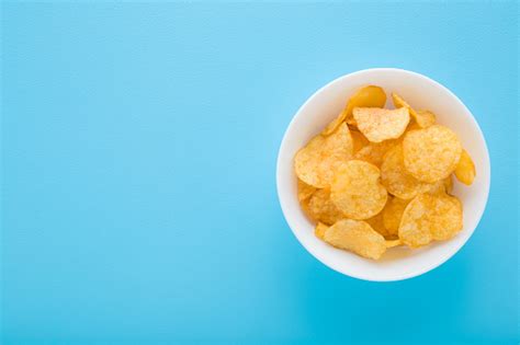 밝은 파란색 테이블 배경에 노란색 감자 칩의 전체 흰색 그릇 파스텔 색상 근접 촬영 텍스트를 위한 빈 공간입니다 하향식 보기 0명에 대한 스톡 사진 및 기타 이미지 Istock