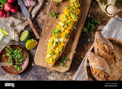 Bio Scrambled Eggs On Rustic French Baguette With Fresh Herbs And