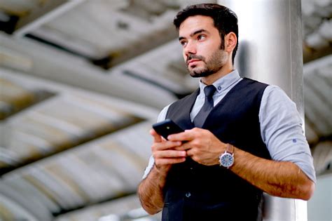 흰색 잘 생긴 사업가는 휴대 전화를 사용하고 지루하고 슬픈 감정을 표현하고 극에 가까이 서 거리에 대한 스톡 사진 및 기타 이미지 거리 경영자 기업 비즈니스 Istock