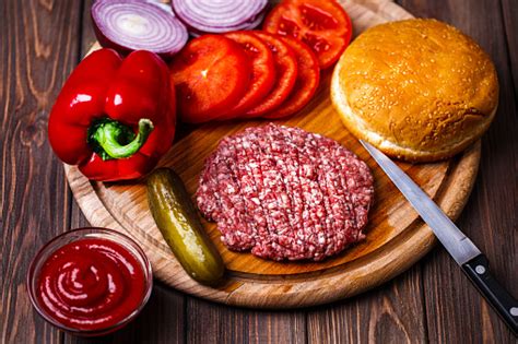 빈티지 나무 판에 조미료 치즈 토마토 샐러드와 롤빵을 곁들인 생 지상 쇠고기 버거 스테이크 커틀릿 가정 생활에 대한 스톡 사진