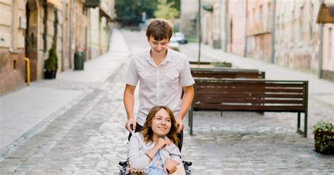 휠체어를 타고 도시를 산책하는 젊은 커플 휠체어를 탄 예쁜 젊은 여자와 오래된 도시의 중심에 있는 그녀의 남자친구 사진 Unsplash의 앉아 이미지