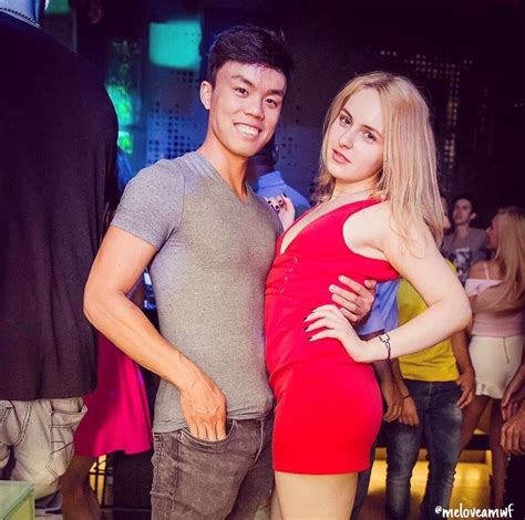 A Man Standing Next To A Woman In A Red Dress