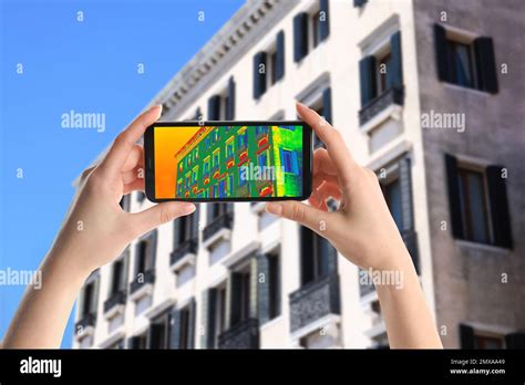 Woman Detecting Heat Loss In Building Using Thermal Viewer On Smartphone Outdoors Energy