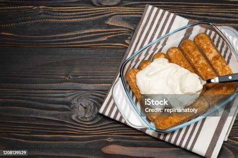 티라미수 디저트 요리 나무 배경에 유리 베이킹 접시에 전통적인 이탈리아 사보이 아르디 레이디 핑거 비스킷과 크림 0명에 대한