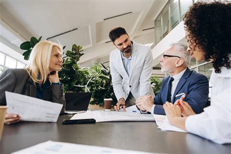 현대 사무실에서 청사진을 가지고 지속 가능한 프로젝트에 대해 논의하는 다인종 비즈니스 팀 25 29세에 대한 스톡 사진 및 기타 이미지 25 29세 35 39세 50