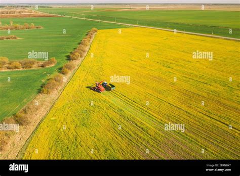 Aerial View Of Rural Landscape Combine Harvester And Tractor Working