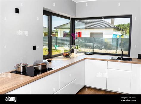 Large Corner Window In A Modern Kitchen With Built In Cabinets Against