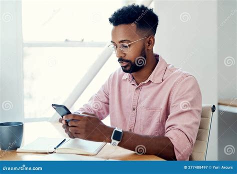 Updating My Schedule A Handsome Young Businessman Sitting Alone And