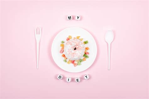 숟가락 포크와 도넛 흰색 접시 장식 장식 및 뿌리 건강에 해로운 정크 식품입니다 다이어트 건강 한 식 생활 라이프 스타일입니다 체중 감량입니다 비만입니다 최소한의 스타일