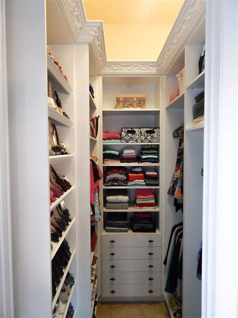 A Walk In Closet Filled With Lots Of Clothes And Shoes On Top Of White