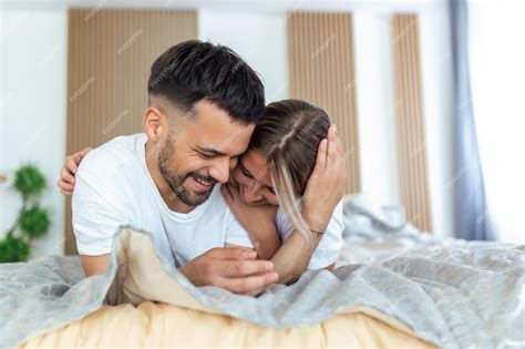 Premium Photo Smiling Couple Going To Kiss Under Sleeping Sheets In