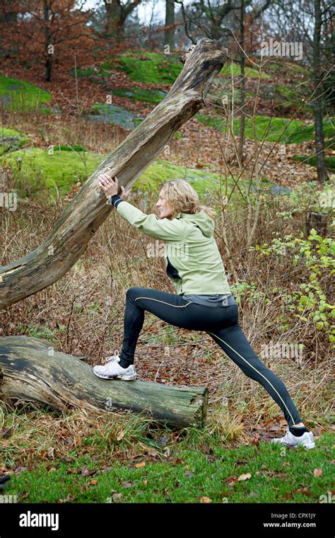 Mature Woman Stretching Against Tree In Forest Stock Photo Alamy Mature Woman Stretching Against Tree In Forest Stock Photo Alamy