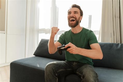 Premium Photo Excited Man Sitting On Comfortable Sofa In Apartment