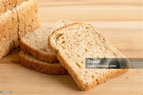 빵 한 덩어리 옆에 있는 밝은 나무위에 고립된 통밀 토스트 빵 세 조각 0명에 대한 스톡 사진 및 기타 이미지 0명 3가지