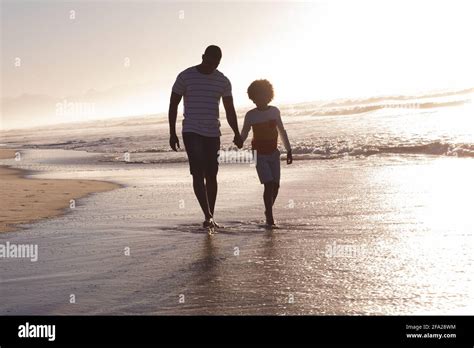 Father And Daughter Walking On Beach