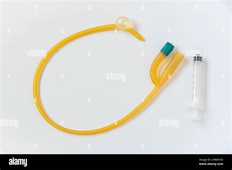 Urinary Foley Catheter With Inflated Balloon And Syringe On White