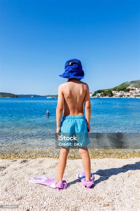 수영복 자외선 차단제 모자와 지느러미에 귀여운 작은 무두질 소년 아이가 맑은 여름 날에 맑은 푸른 지중해 바다 물에서 재미있는 산책 다이빙 아이는 오리발을 타고 스노클링을