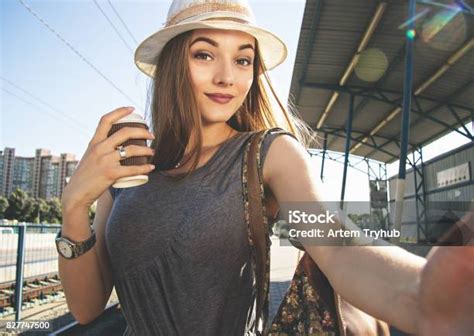 Selfie 여행 아름 답 고 젊은 여자 드레스와 모자에 카메라를 유지 하 고 도시 여행 동안 기차에 커피와 함께 Selfie를
