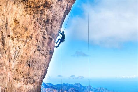 Premium Photo Man Rock Climbing Against Sky