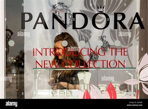 A Young Female Shop Assistant Arranging Window Display Cabinet Inside The Pandora Jewellery Shop