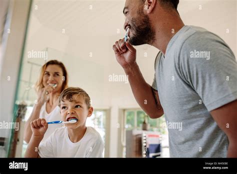 Cute little boy se brosser les dents avec son père et sa mère dans la salle de bains Jeune