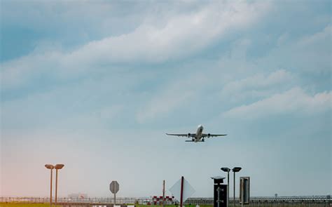 여객기는 공항 아름 다운 푸른 하늘과 구름에 내려요 비행을 떠난다 해외 여행을 시작 합니다 휴가 시간 공항에서 울타리와 태양