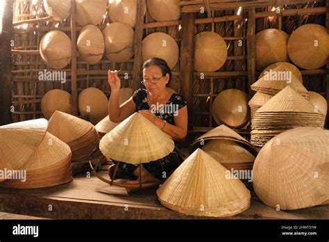 Old Vietnamese Woman Making A Traditional Conical Hat At Her Home Stock