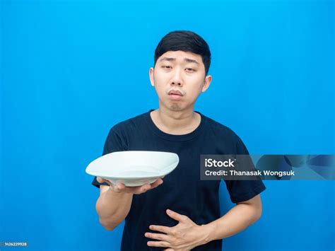 배고픈 푸른 배경을 느끼는 접시와 터치 배꼽을 들고있는 남자 손에 대한 스톡 사진 및 기타 이미지 손 30 34세 감정