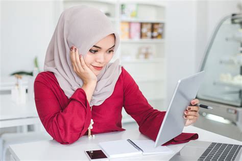 젊은 아시아 무슬림 여자는 생각과 흰색 카페에서 태블릿을 사용 하는 경영자에 대한 스톡 사진 및 기타 이미지 경영자 교육 디지털 태블릿 사용하기 Istock