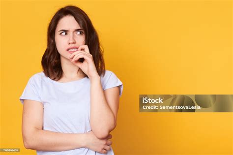 사려 깊은 여성의 수평 초상화는 옆으로 찾고 얼굴 가까이 손을 유지 어떤 결정을 내릴 생각 하 고 빈 복사 공간 노란색 배경에