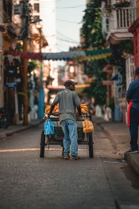 Foto Un Hombre Empujando Un Carro Por Una Calle Imagen Cartagena Gratis En Unsplash